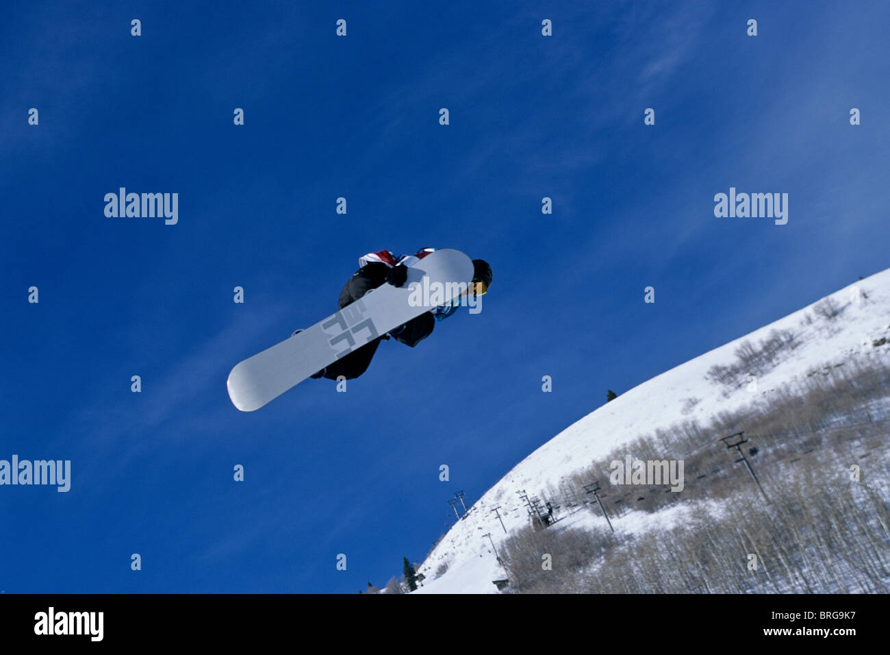 Male snowboarder flying through the air Stock Photo - Alamy
