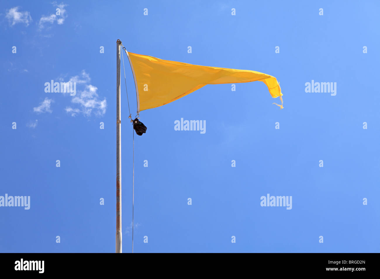 yellow warning flag on the beach against blue sky Stock Photo - Alamy