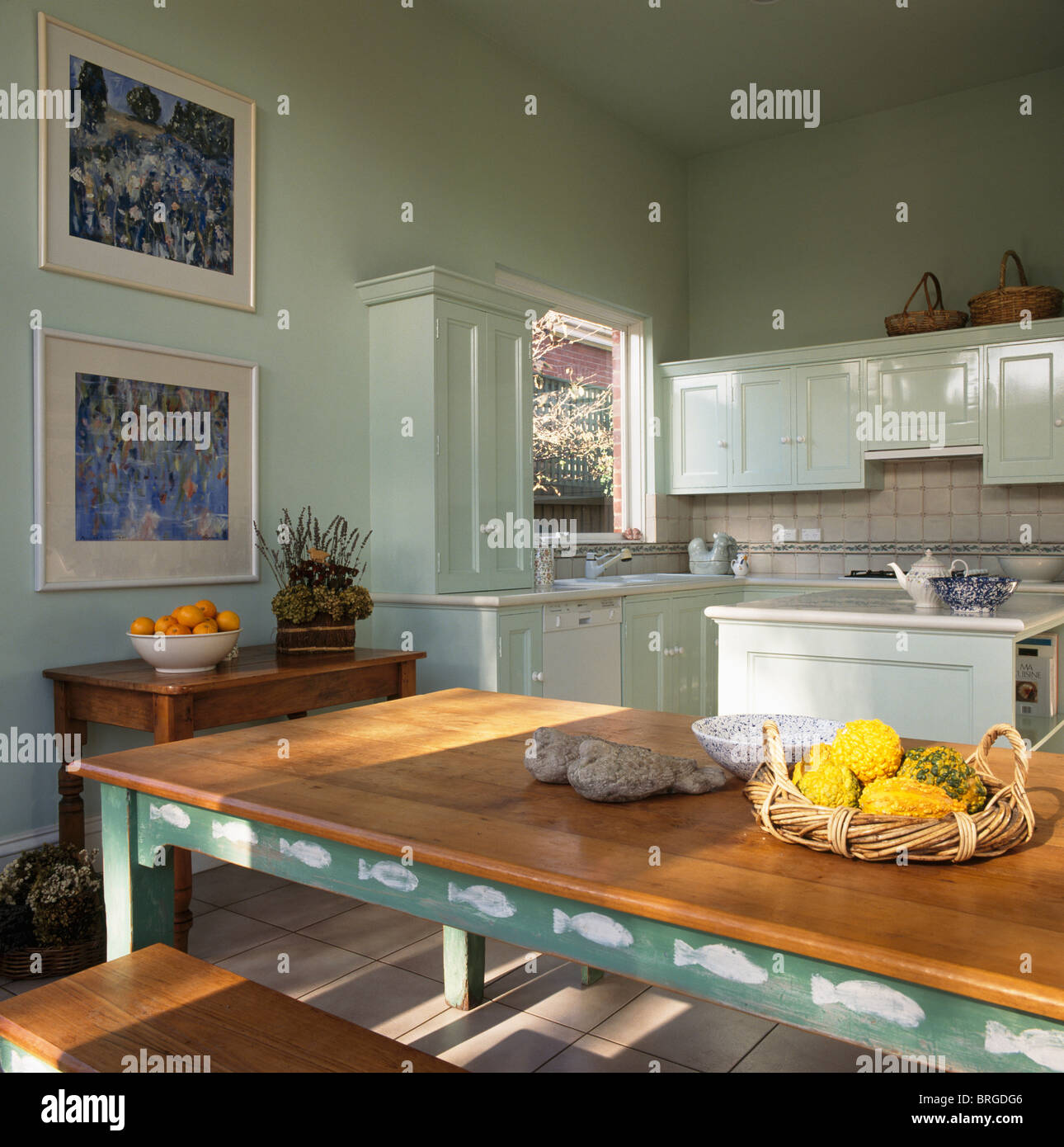 Pale green kitchen with green stenciled table with stripped wooden top ...