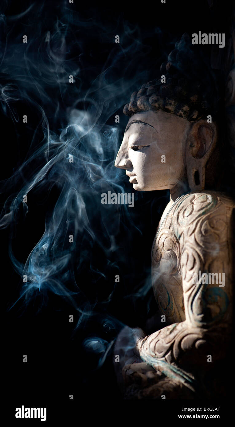 Buddha statue and incense smoke Stock Photo - Alamy