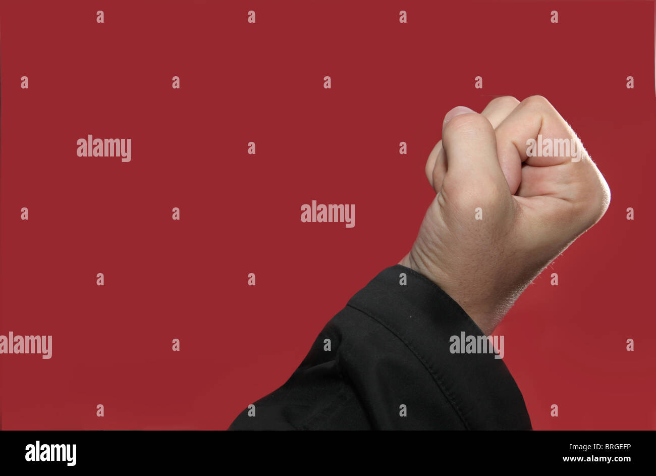 Male Caucasian hand clenched in anger against a red background Stock ...