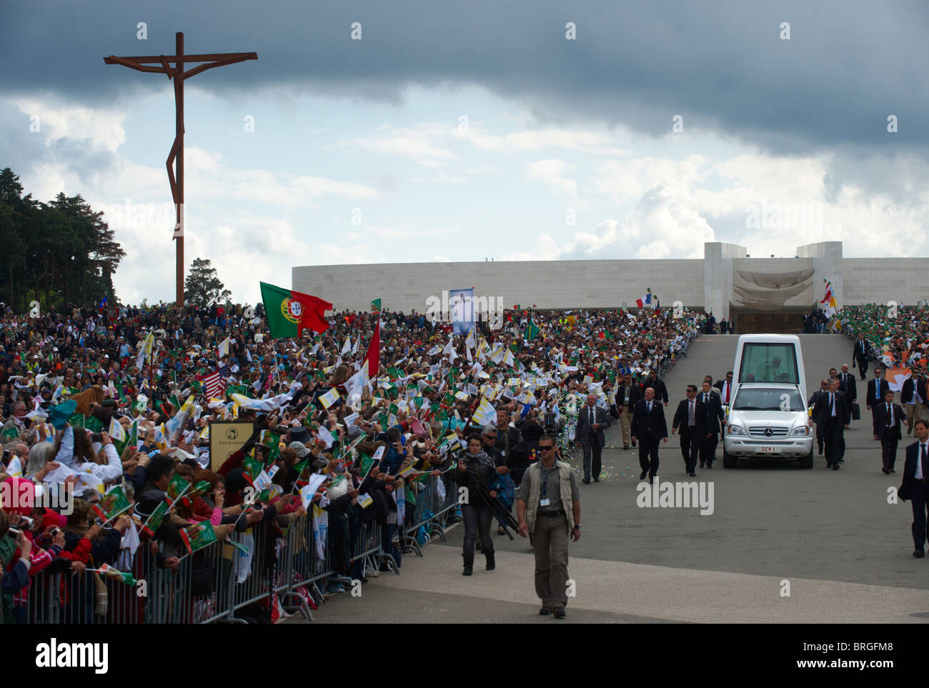 Pope Benedict XVI waves at pilgrims from inside his armored car at the ...