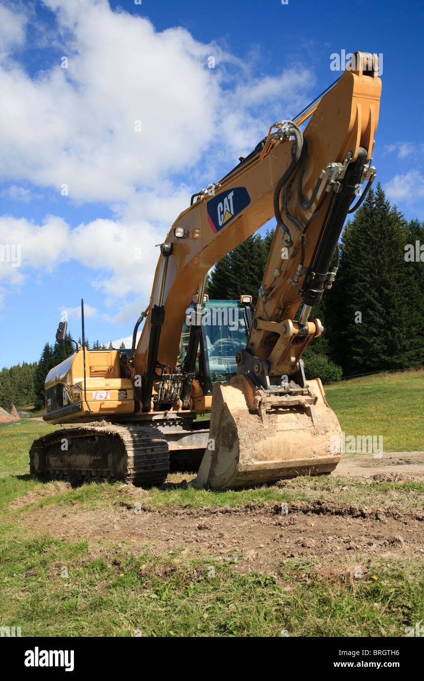 CAT digger on Alpine ski-slope in summer Stock Photo - Alamy