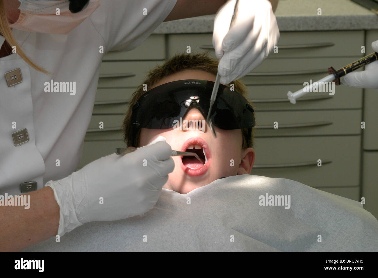 Young child having dental check-up inspecting teeth and checking ...