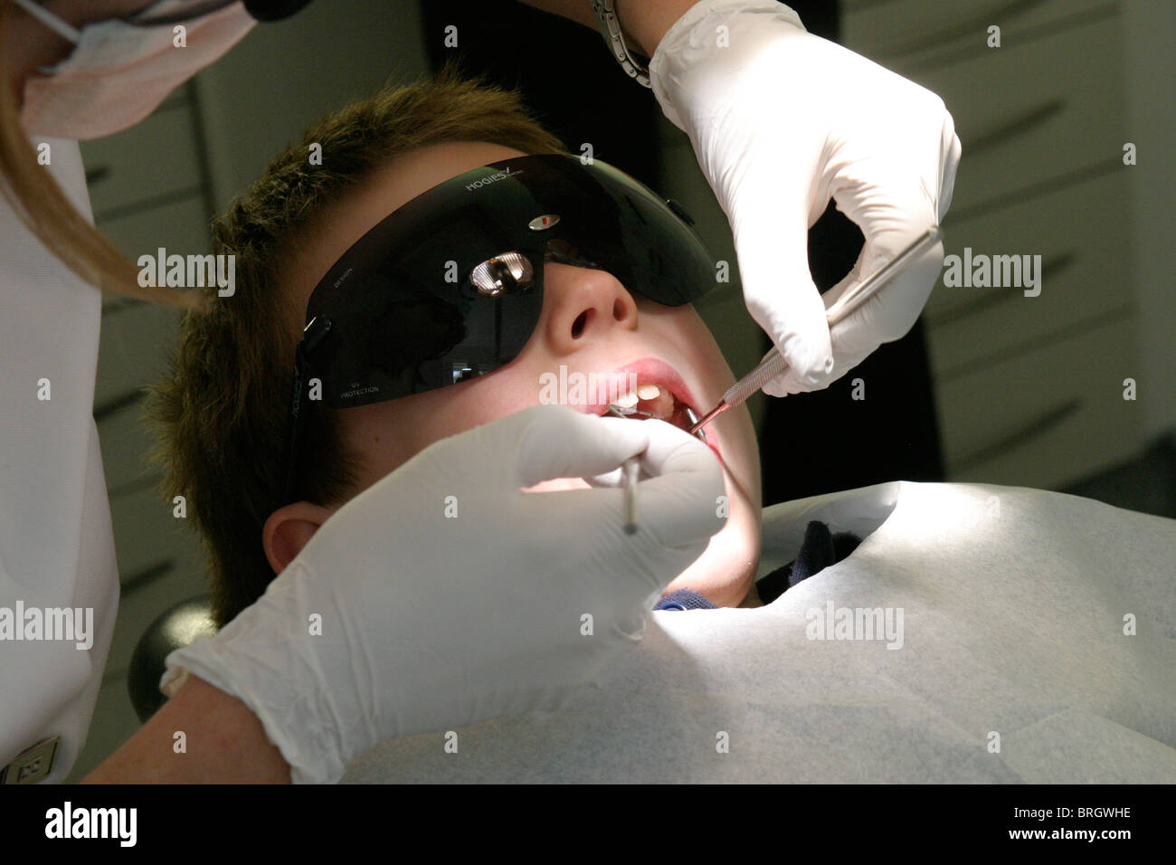 Young child having dental check-up inspecting teeth and checking ...