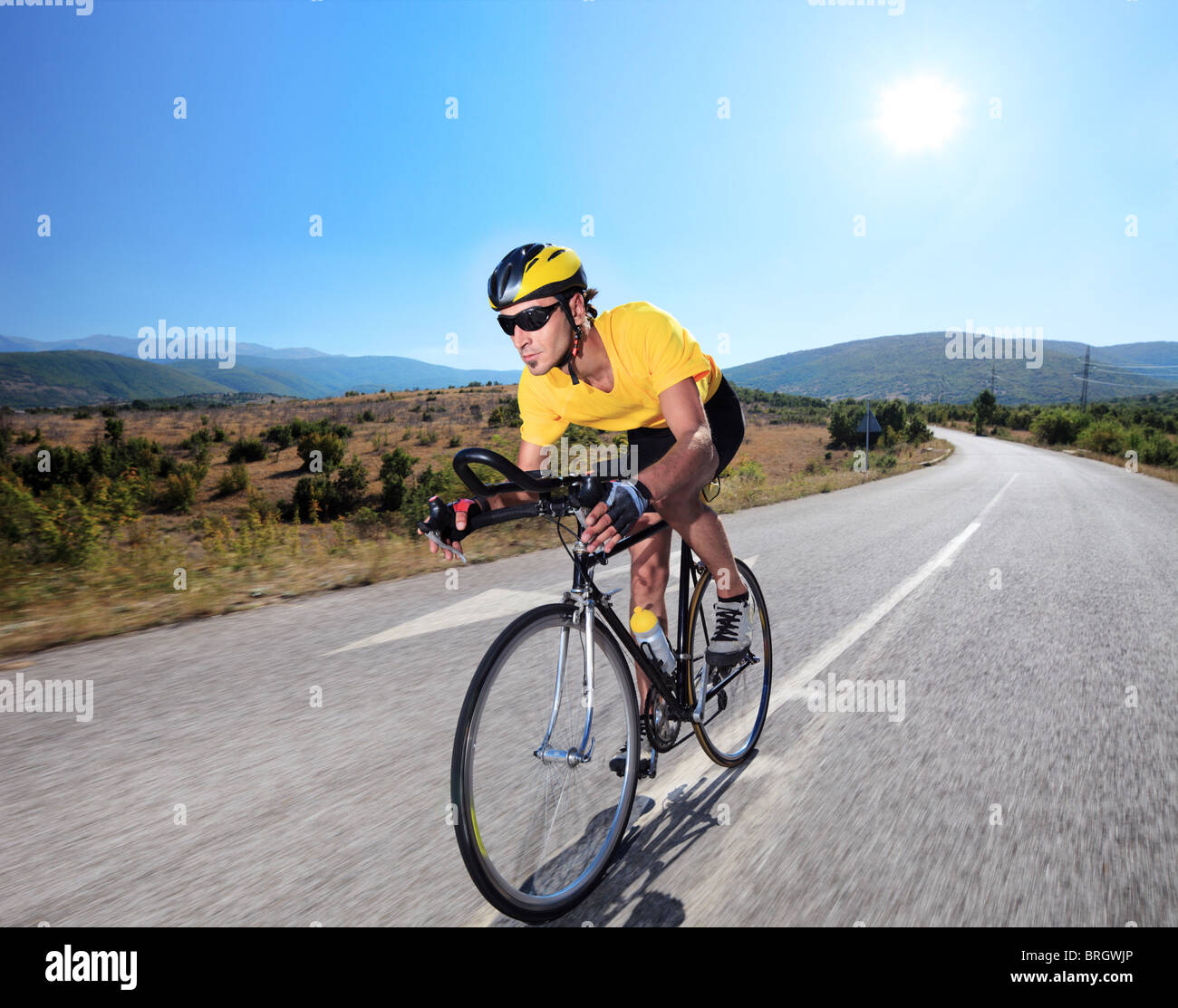 Cyclist riding a bike on an open road Stock Photo - Alamy