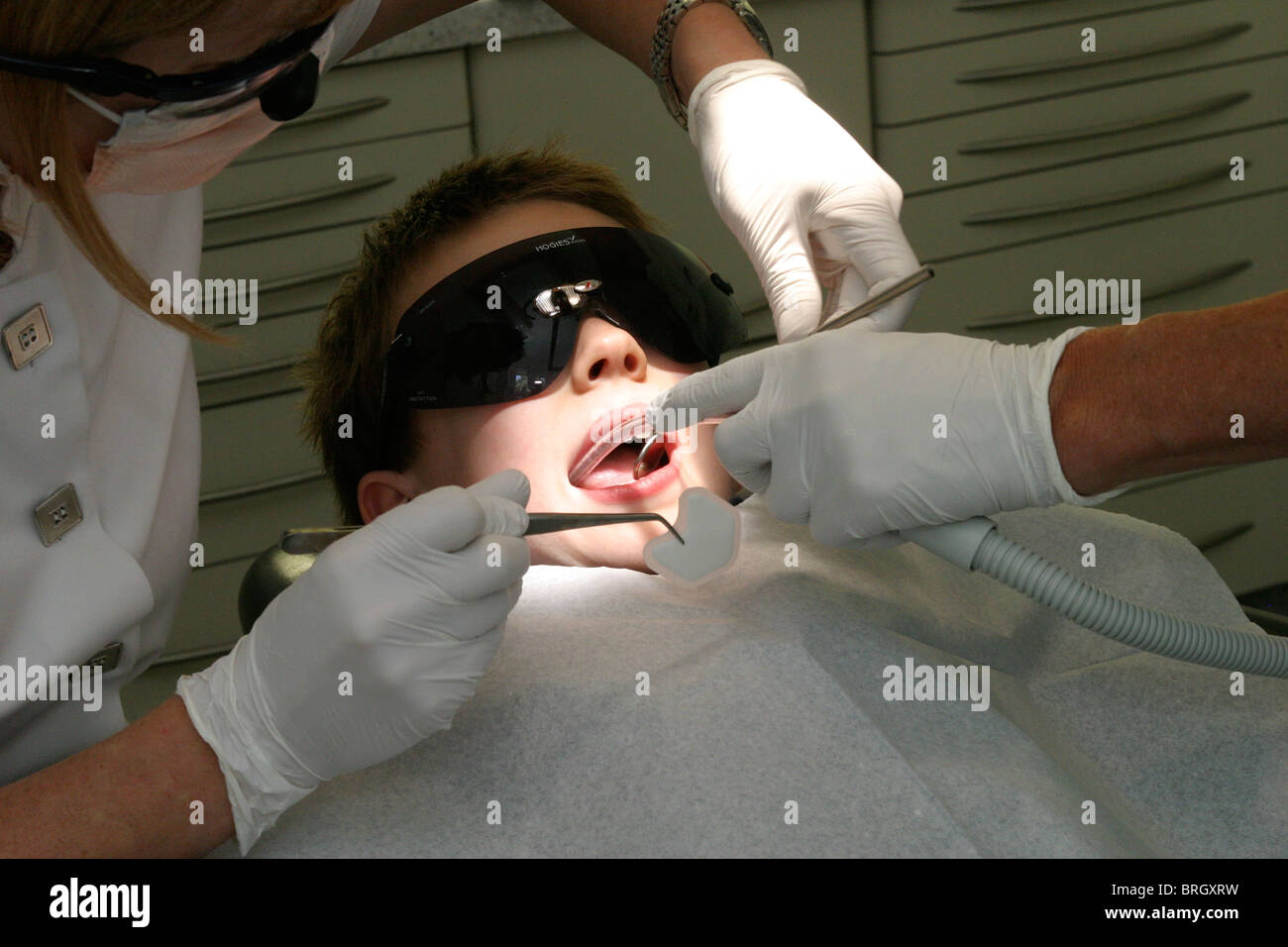 Young child having dental check-up inspecting teeth and checking ...