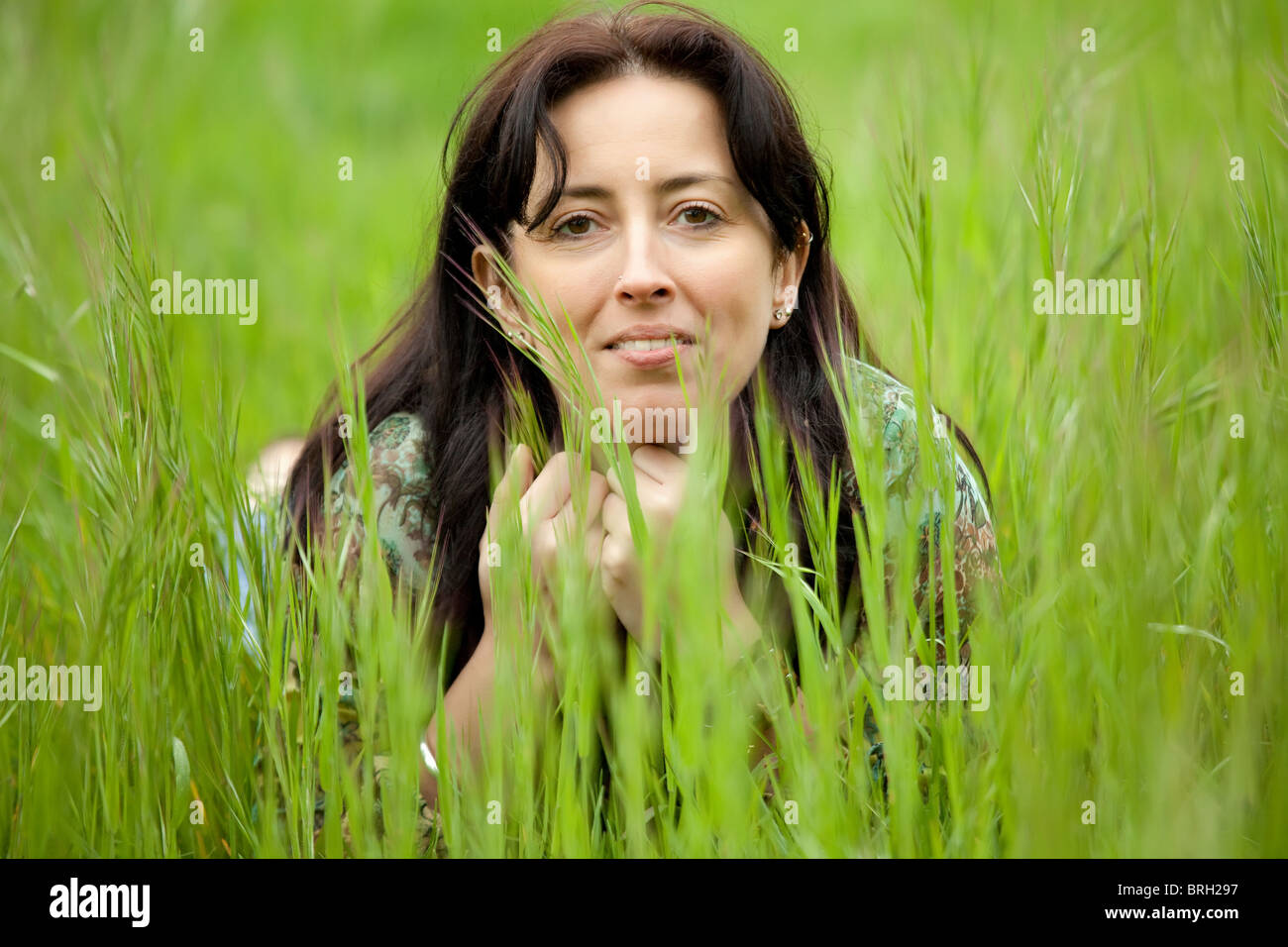 happy woman lying in grass looking at camera Stock Photo - Alamy