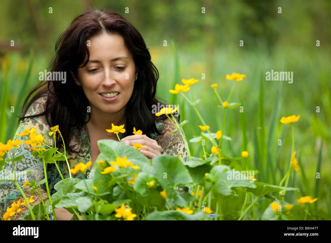 woman in wild nature smelling yellow flower Stock Photo - Alamy