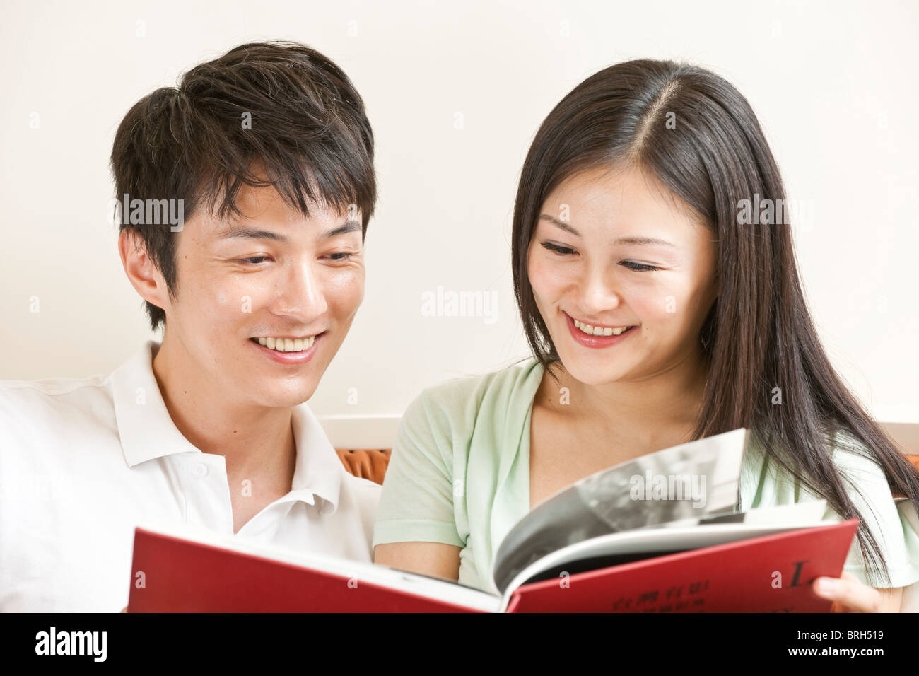 Young couple reading a book Stock Photo - Alamy