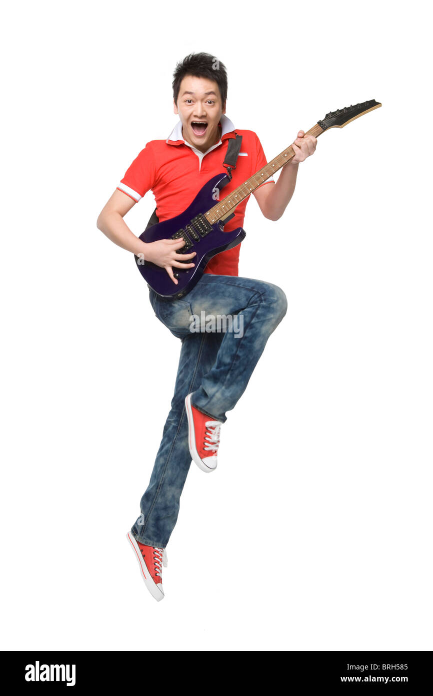 Young man playing an electric guitar Stock Photo - Alamy