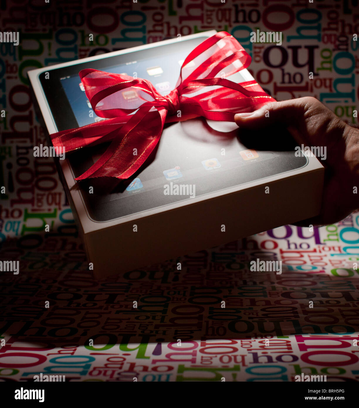 A man's hand giving a boxed iPad as a gift Stock Photo - Alamy