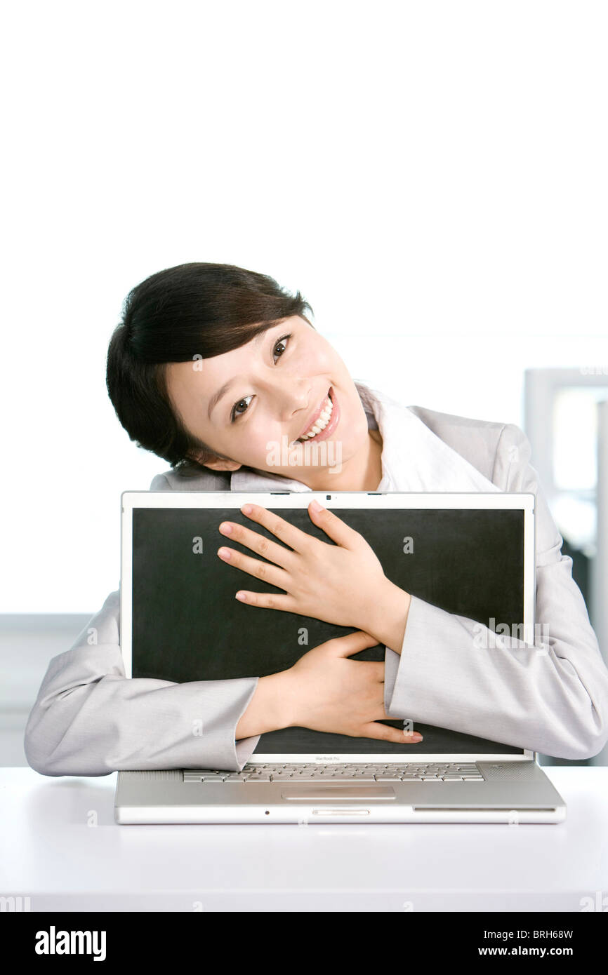 Office worker hugging her computer Stock Photo - Alamy