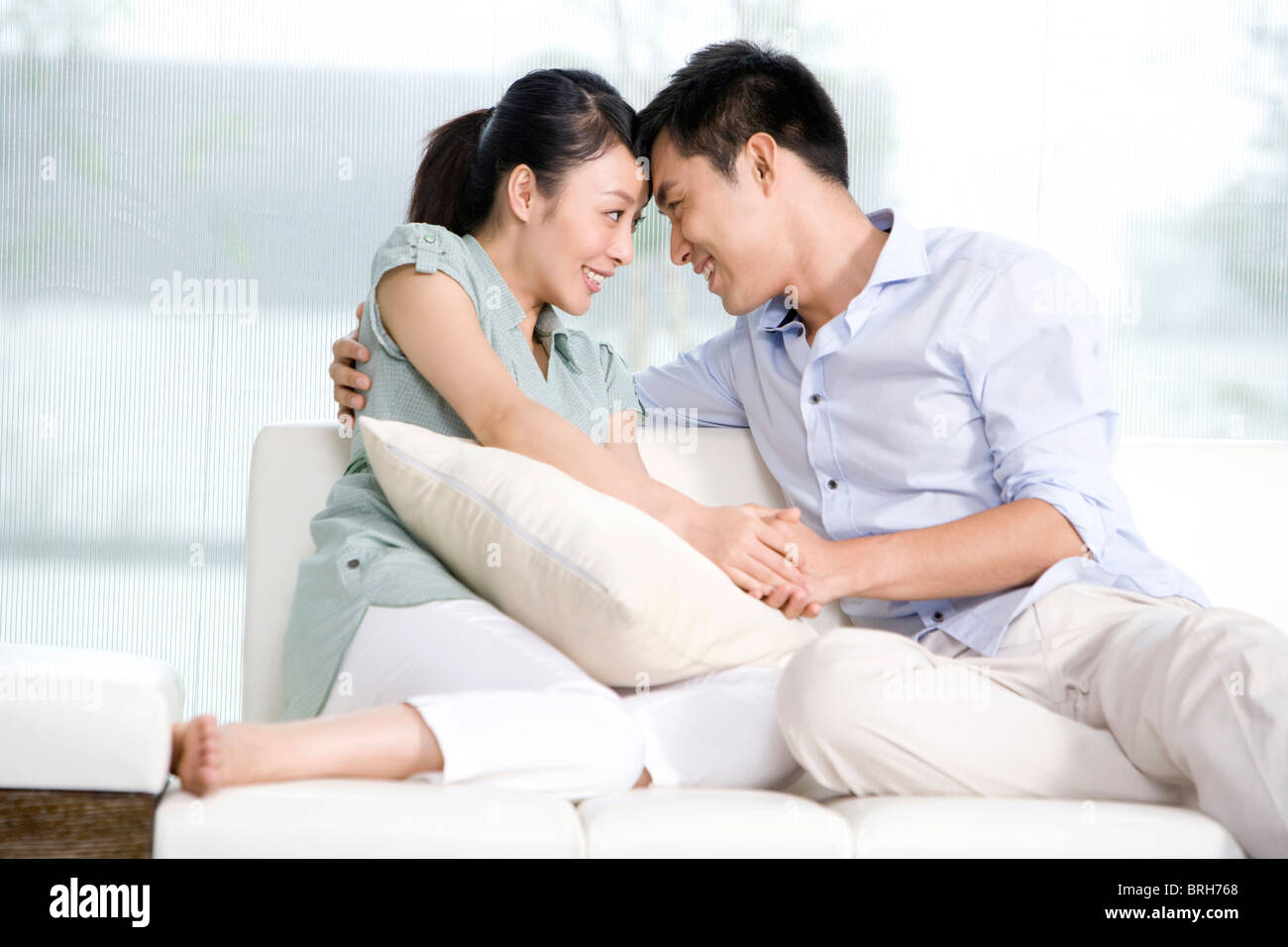 Portrait of a couple relaxing on the couch Stock Photo - Alamy