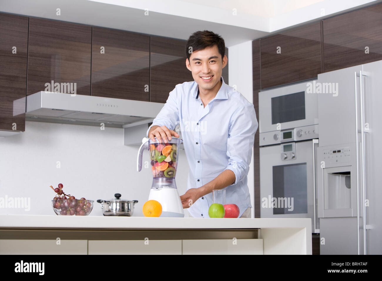 Man making fresh fruit juice Stock Photo - Alamy
