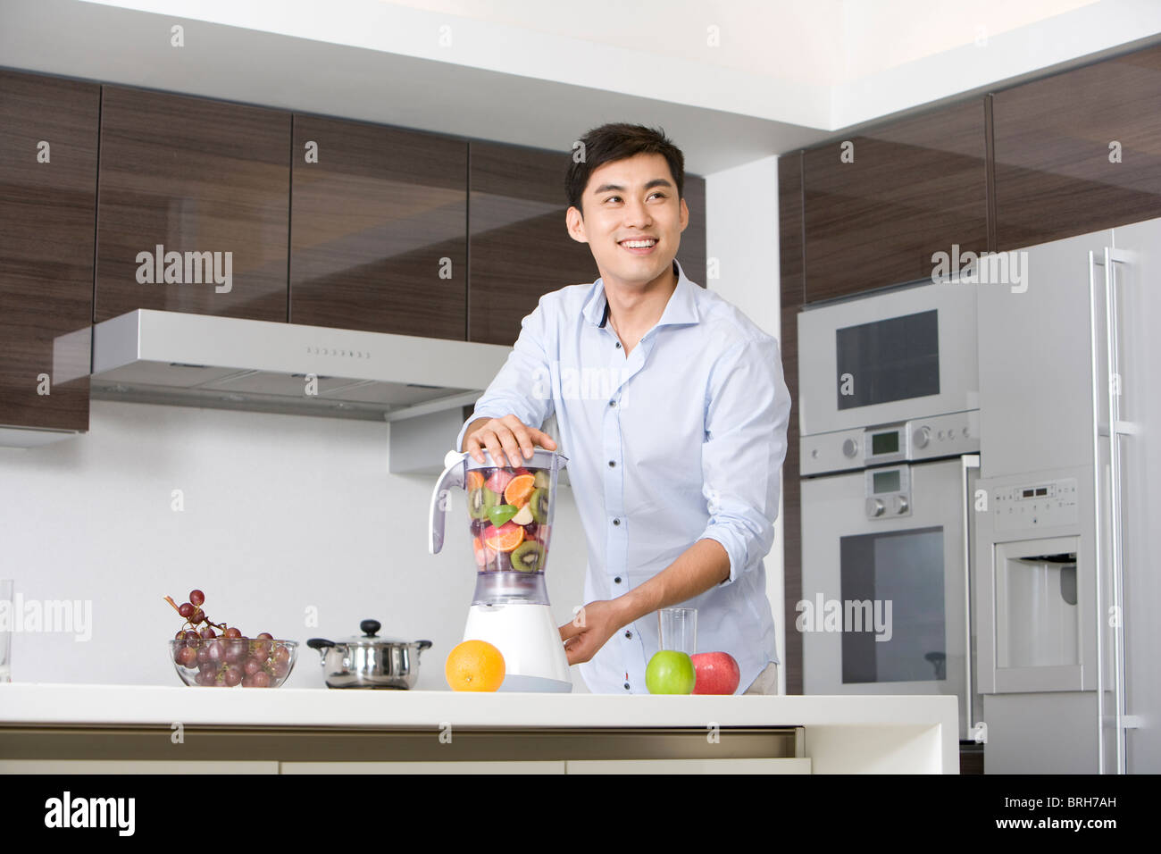 Man making fresh fruit juice Stock Photo - Alamy