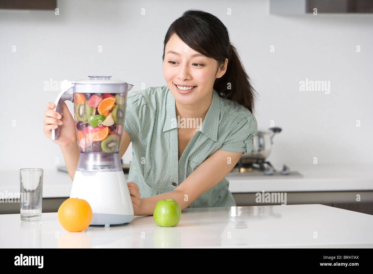 Woman making fresh fruit juice Stock Photo - Alamy