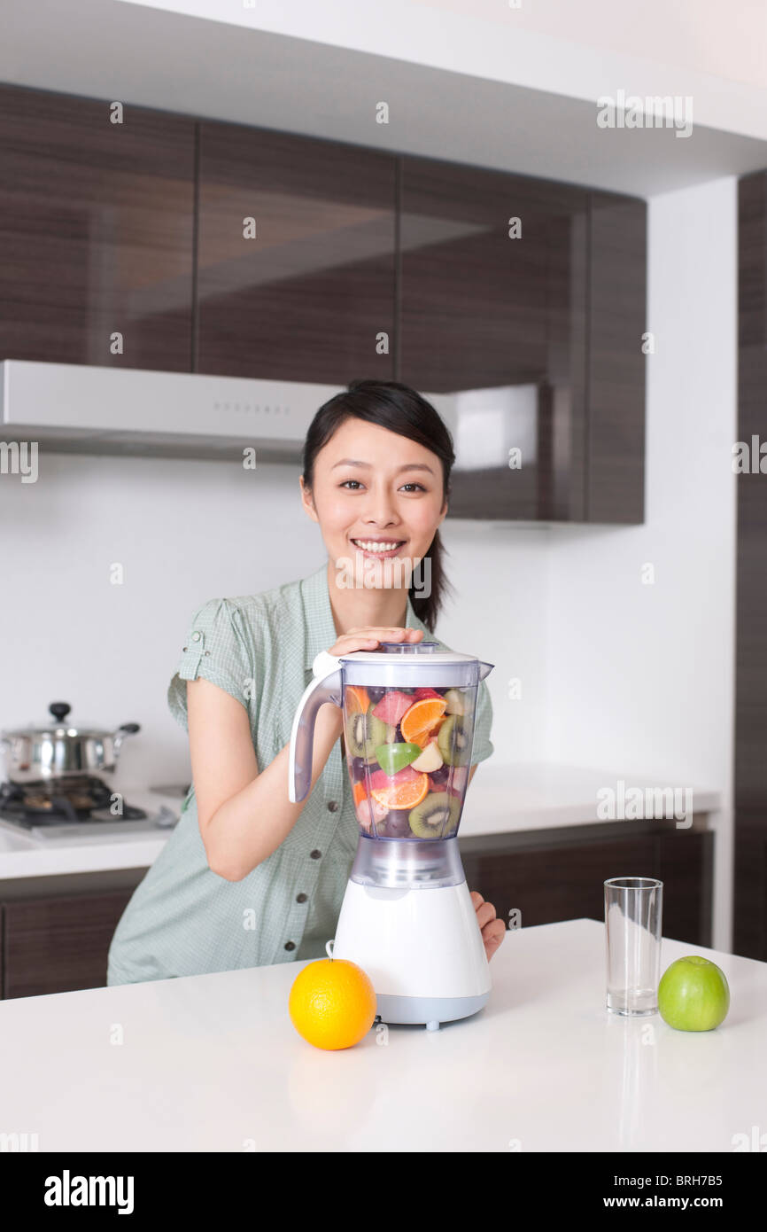 Woman making fresh fruit juice Stock Photo - Alamy