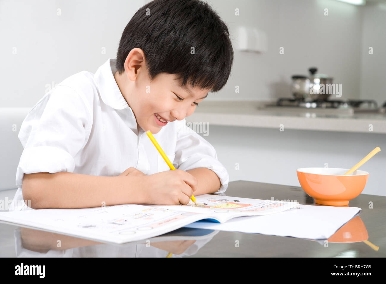 Young boy doing homework in kitchen Stock Photo - Alamy