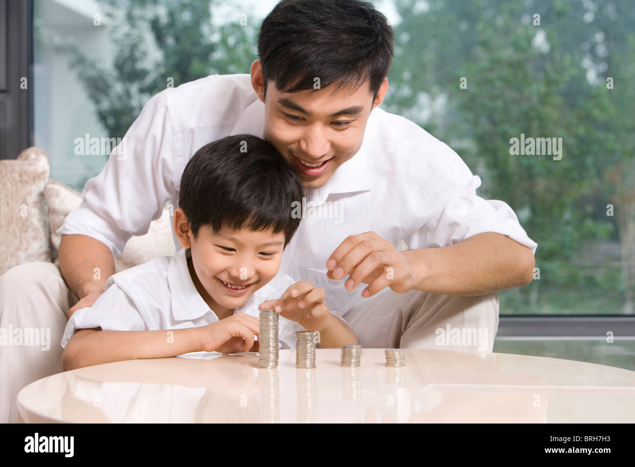 Father and son calculating coins Stock Photo - Alamy