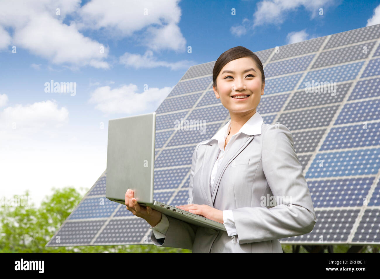 Businesswoman with a laptop in front of solar panels Stock Photo - Alamy