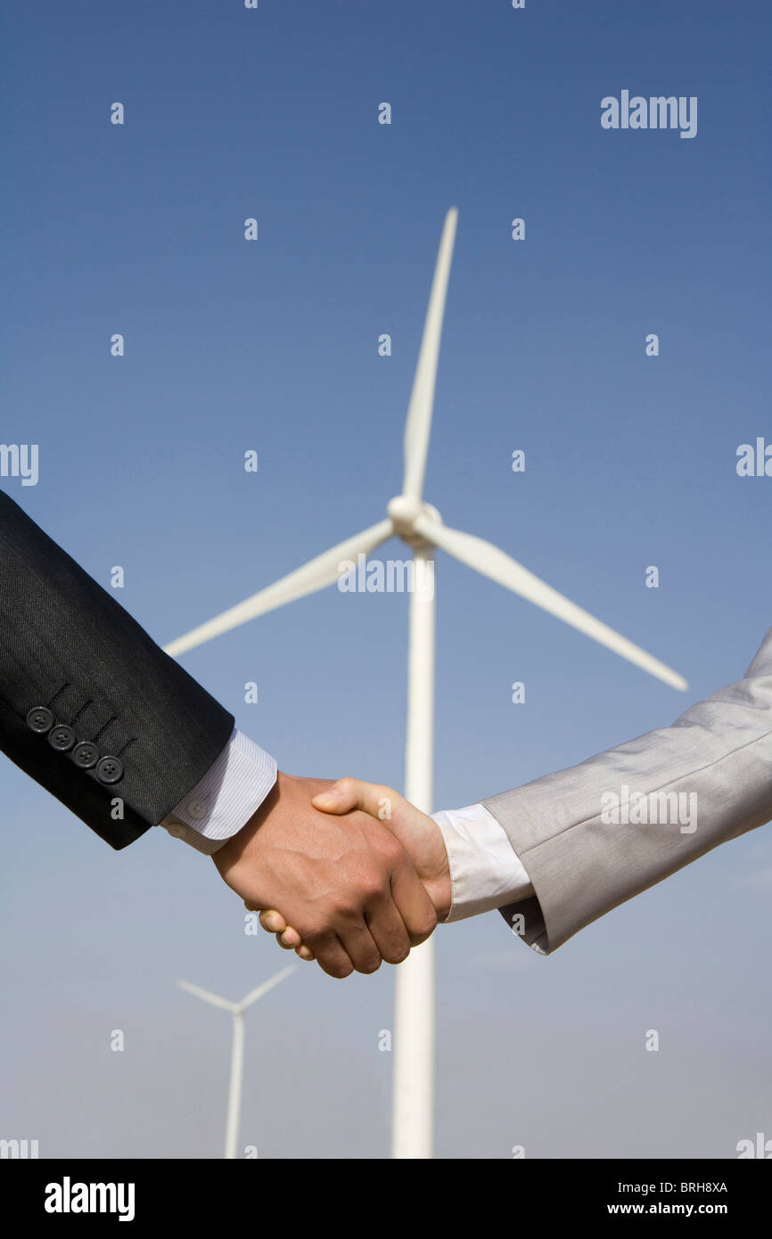 Handshake in front of wind turbines Stock Photo - Alamy