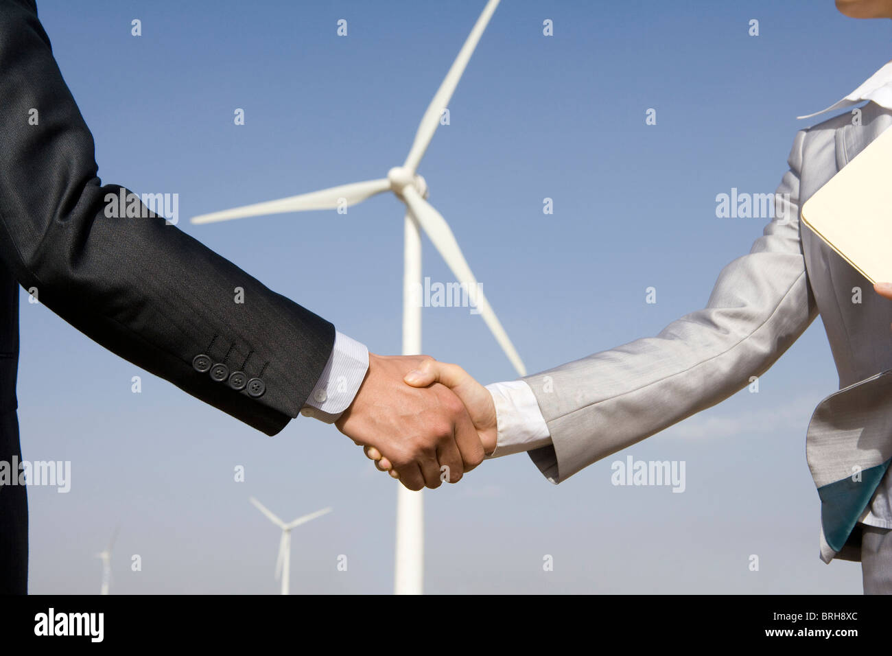 Handshake in front of wind turbines Stock Photo - Alamy
