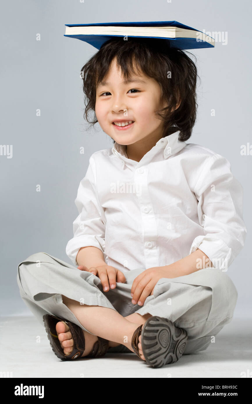 Boy balancing a book on his head Stock Photo - Alamy