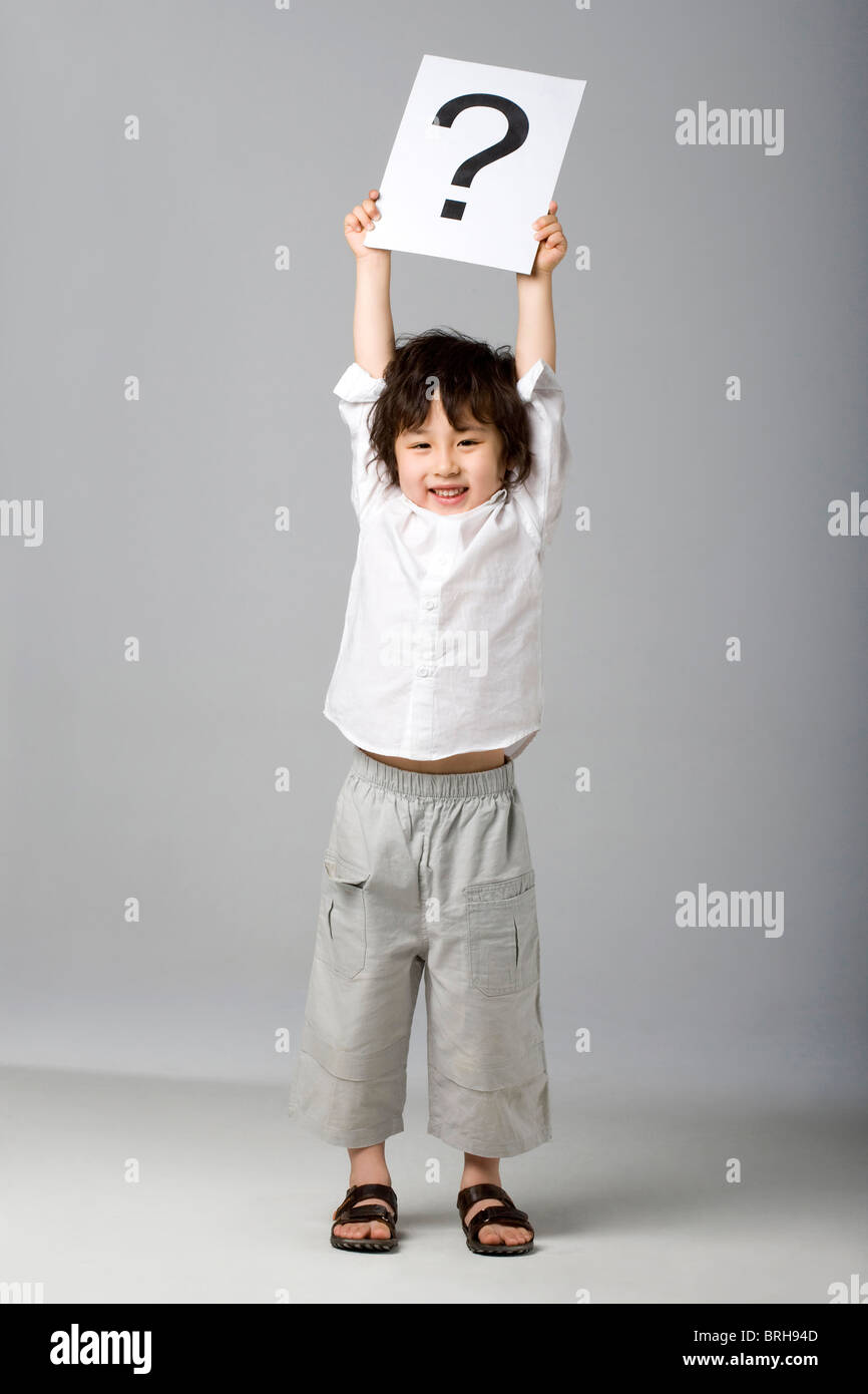 Little boy holding a sign with a question mark Stock Photo - Alamy