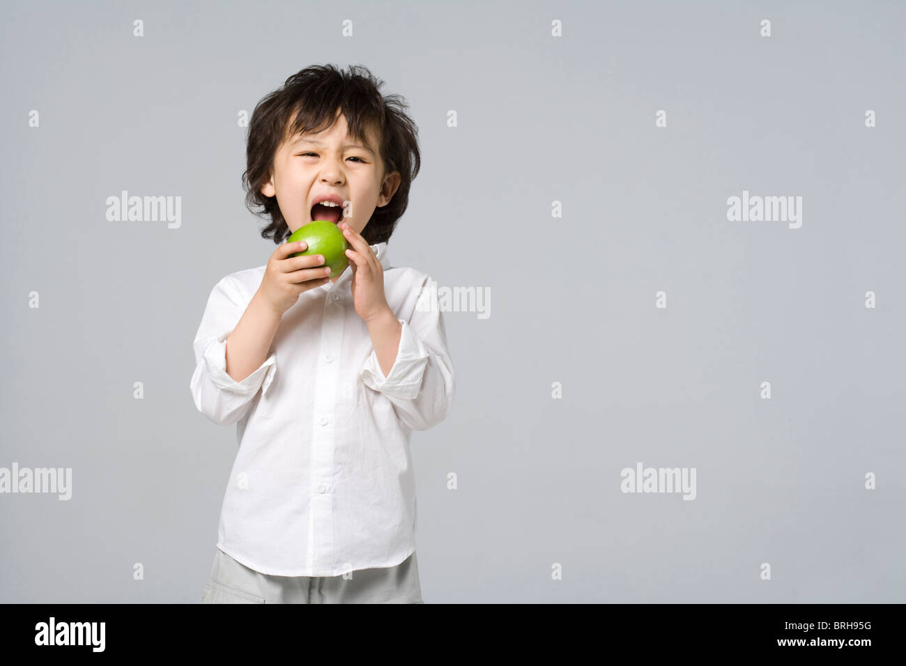 Little boy biting into an apple Stock Photo - Alamy