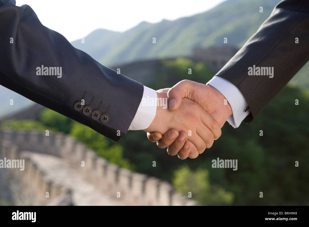 Businessmen shaking hands on the Great Wall Stock Photo - Alamy