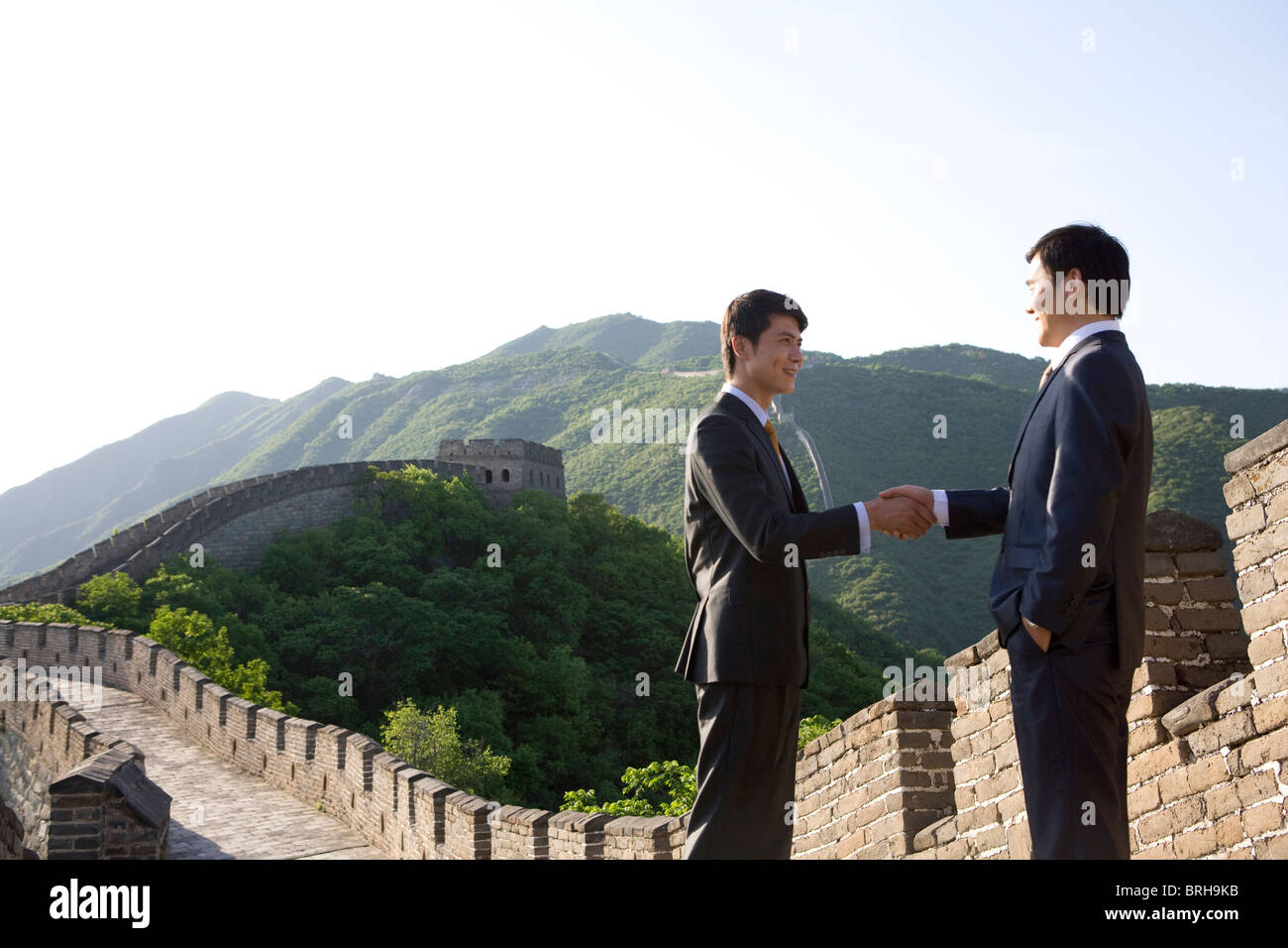 Businessmen shaking hands on the Great Wall Stock Photo - Alamy