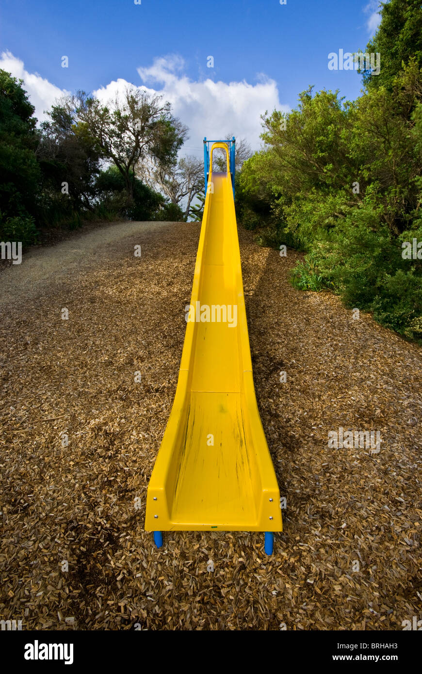 A long, straight bright yellow children's slide in a playground Stock ...