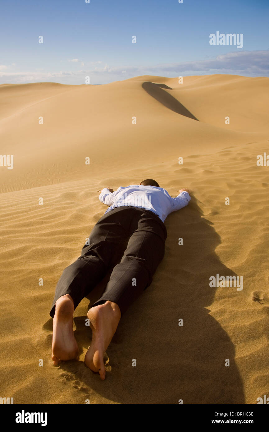 Businessman dead in the desert Stock Photo - Alamy