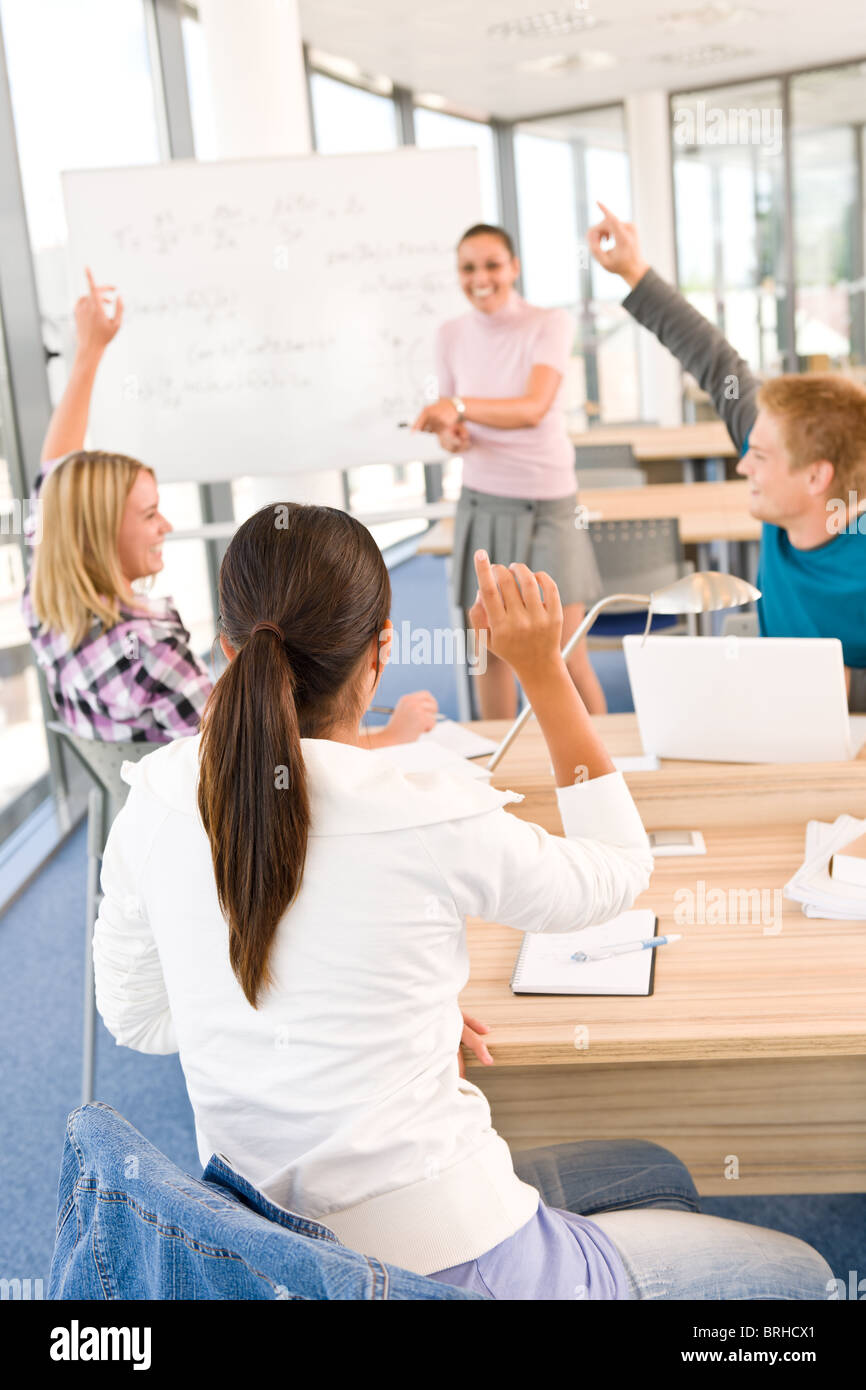 High school students raising hands, in classroom with professor Stock ...