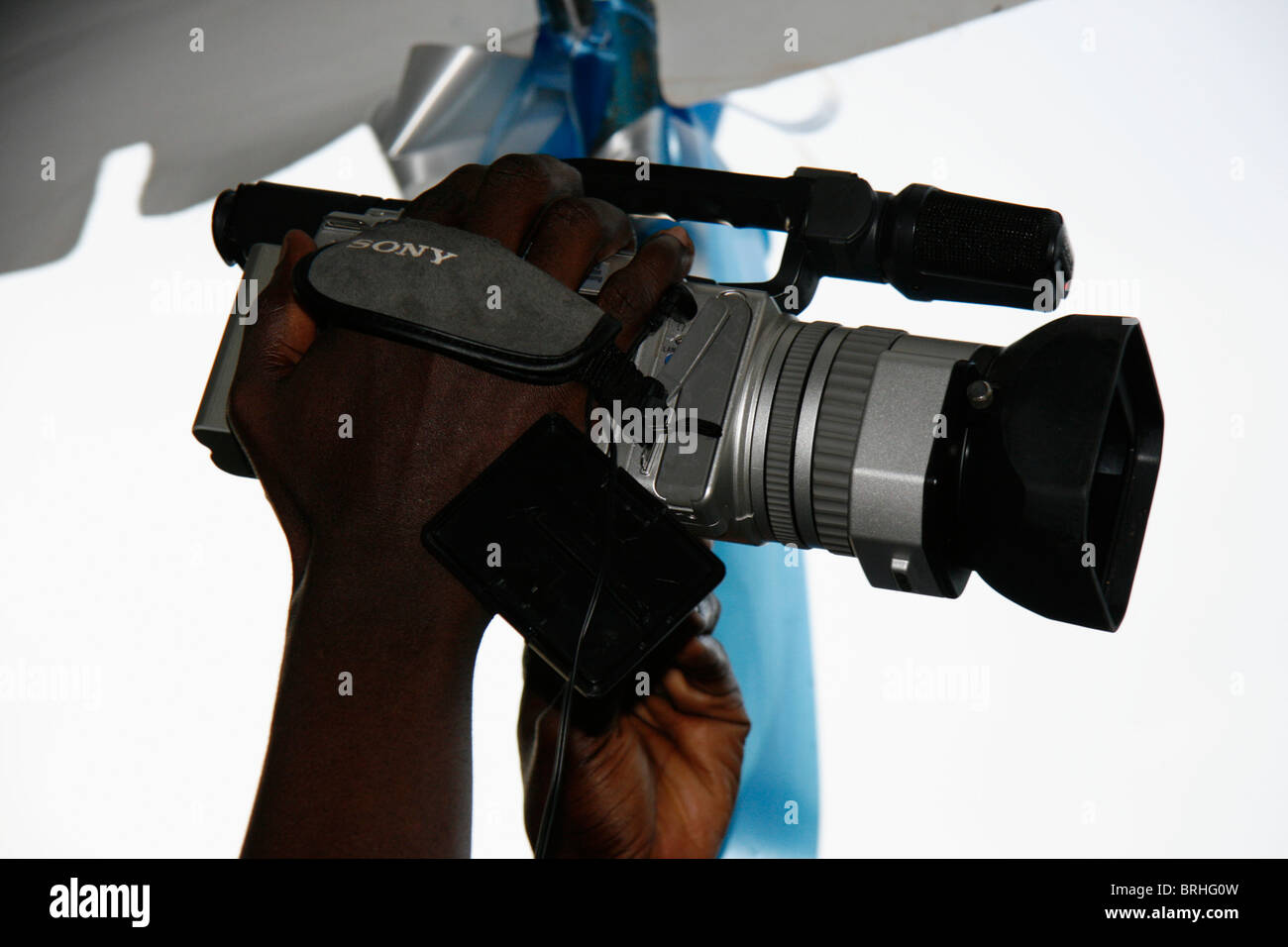 A photographer lifts his video camera high to shoot over a crowd Stock ...