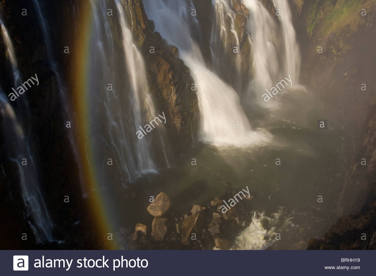 A rainbow cast over a powerful waterfall Stock Photo - Alamy
