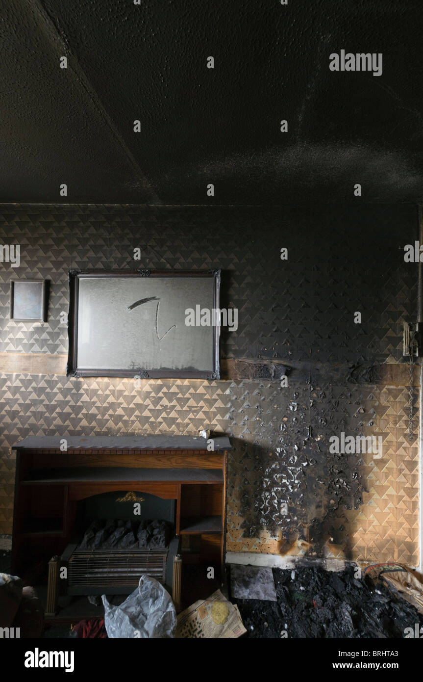 Fireplace and living room in a flat destroyed by fire and smoke damage ...