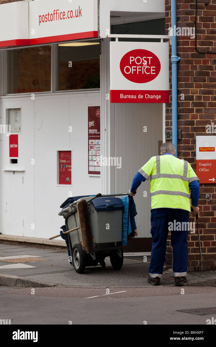 Street cleaner picking up litter by a post office Stock Photo - Alamy