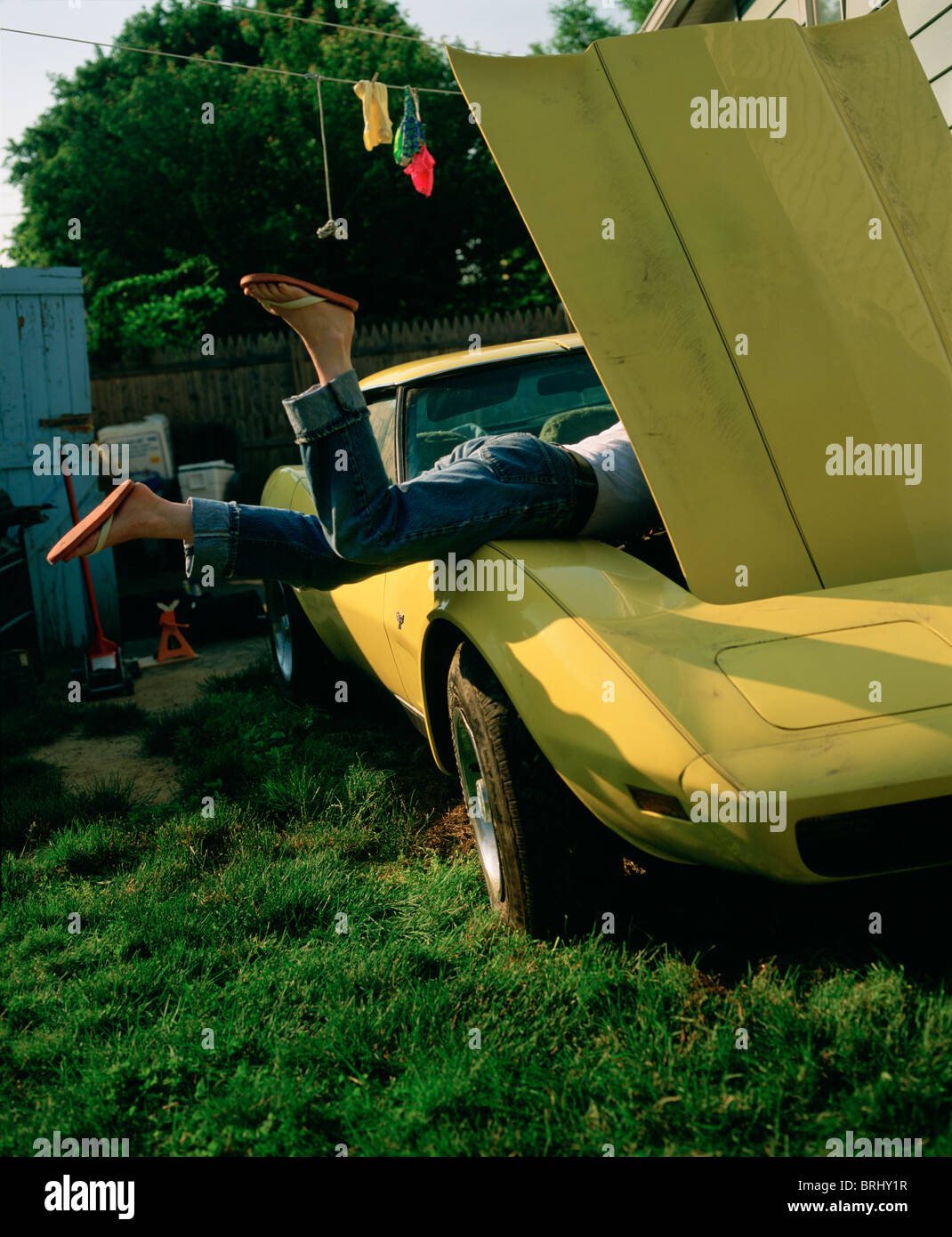 woman mechanic awkward pose on corvette fixing car engine Stock Photo ...