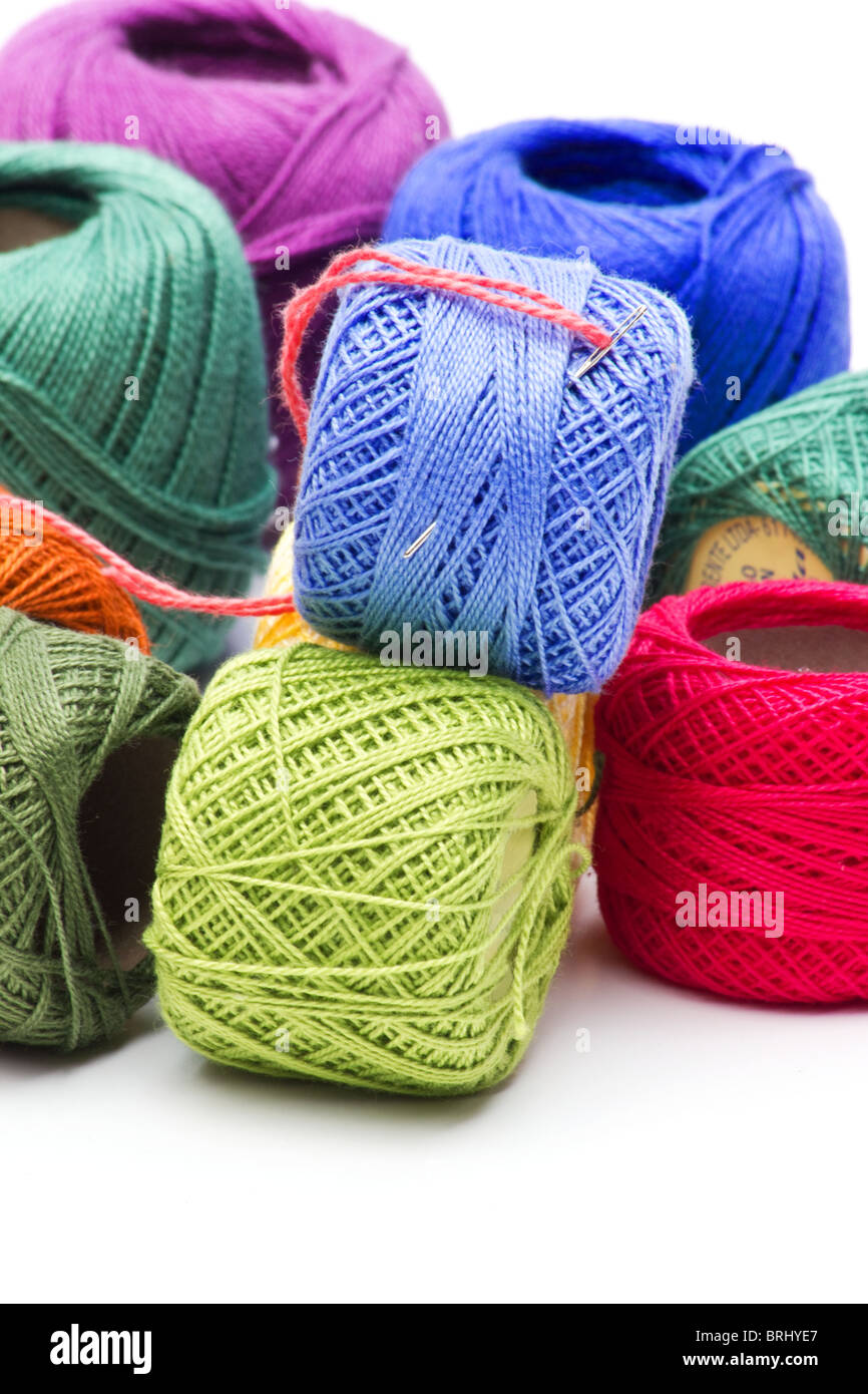 Close-up of multicolored spools of embroidery thread on white ...