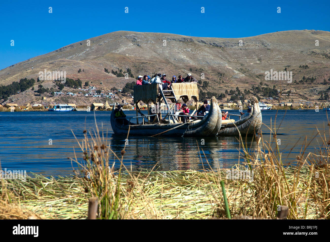 A boat made from totora reeds takes tourists for a ride at the floating ...