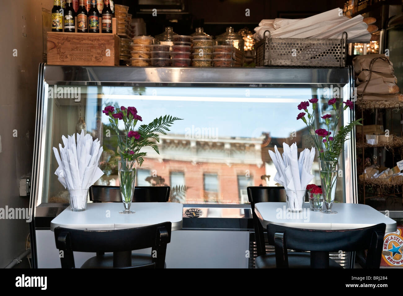two pretty little tables set with flowers in open window of Ninth ...
