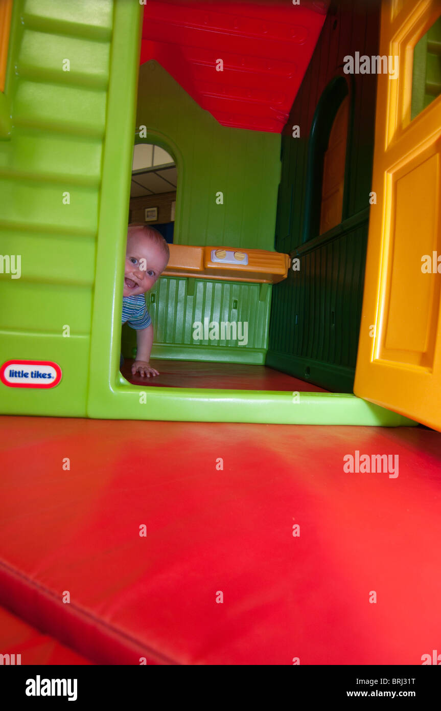 Baby peeking round play house door Stock Photo - Alamy