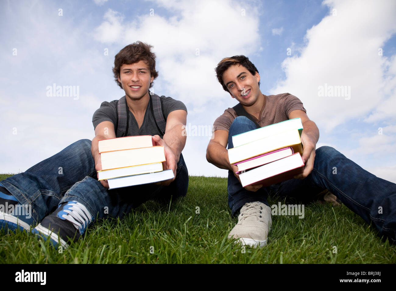two young students giving you books Stock Photo - Alamy