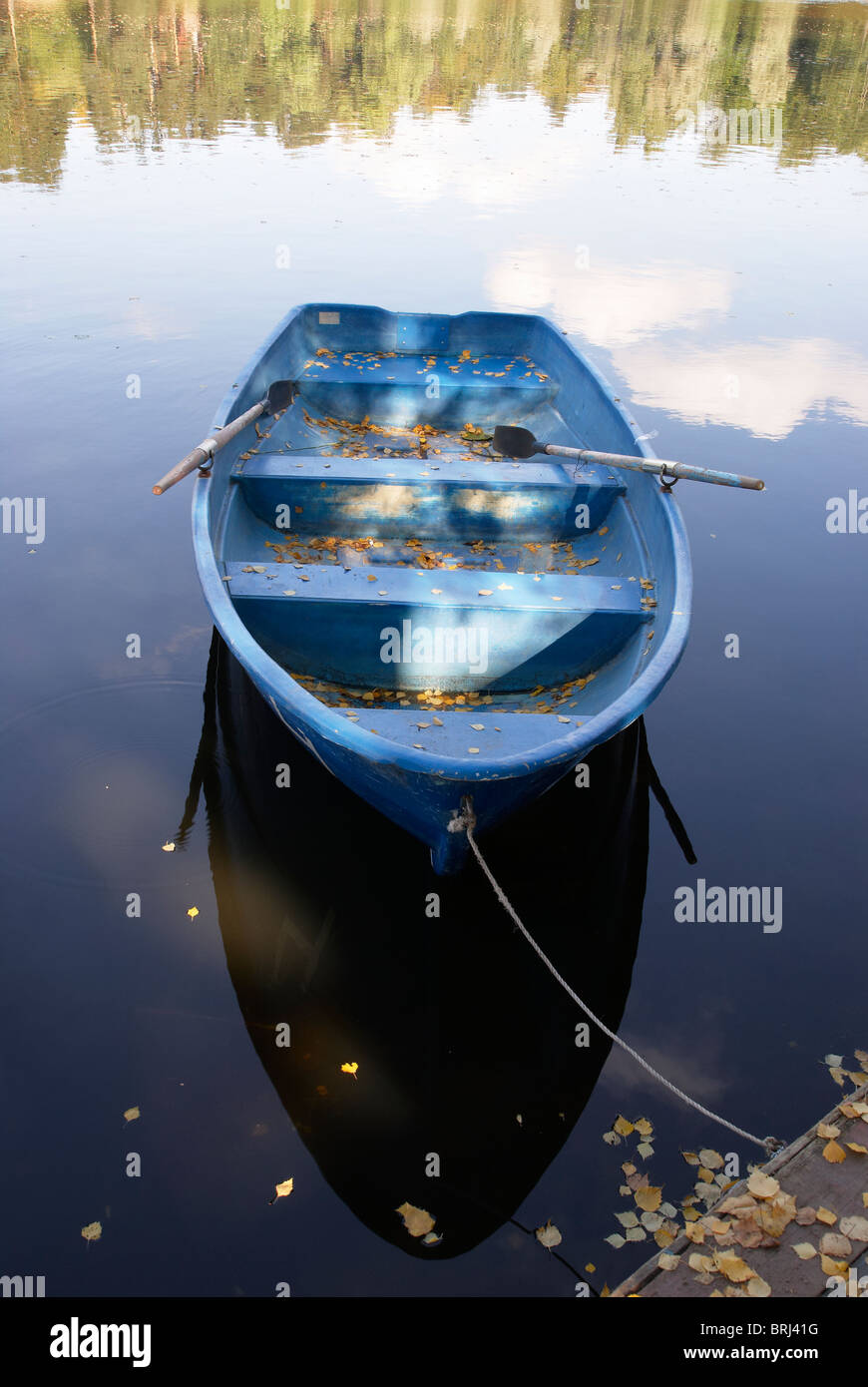 An empty boat on a lake and reflection is in water Stock Photo - Alamy