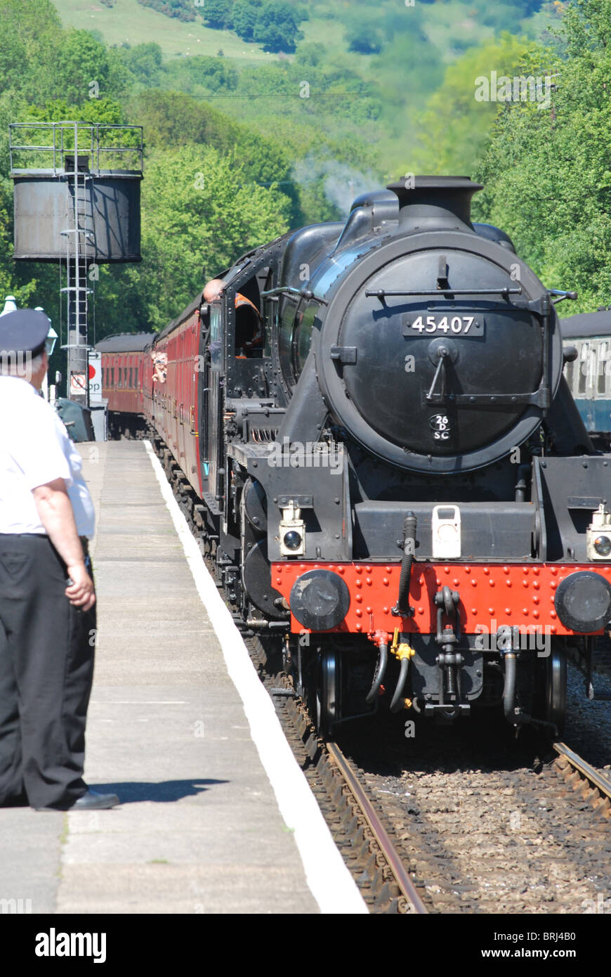 Steam train pulling into Grosmont station with guard Stock Photo - Alamy