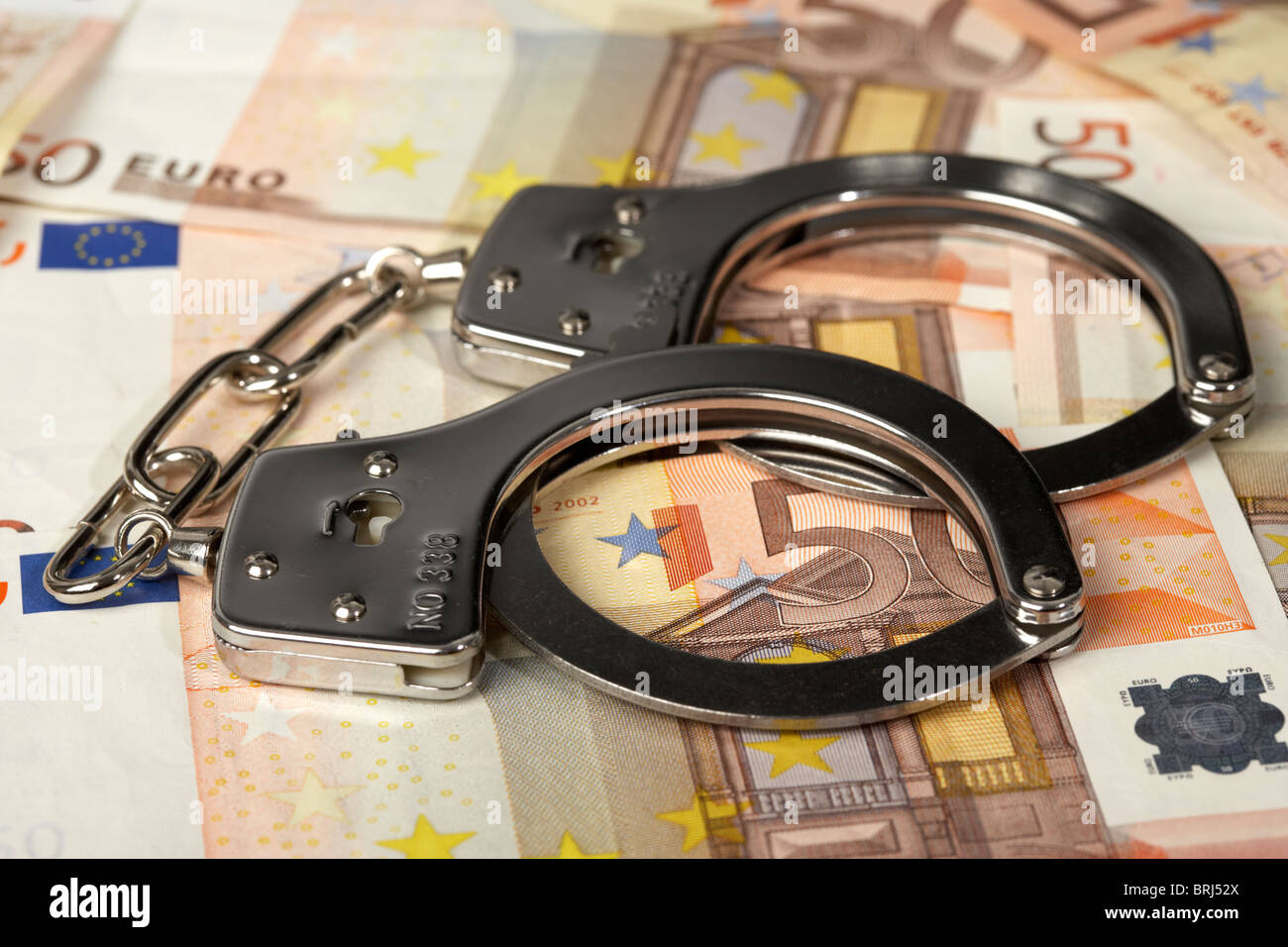 handcuffs on a pile of fifty euro banknotes Stock Photo - Alamy handcuffs on a pile of fifty euro banknotes Stock Photo - Alamy