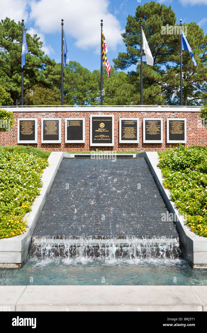 Fountain with 13 colonial flags at entrance to Colonial Williamsburg, a ...