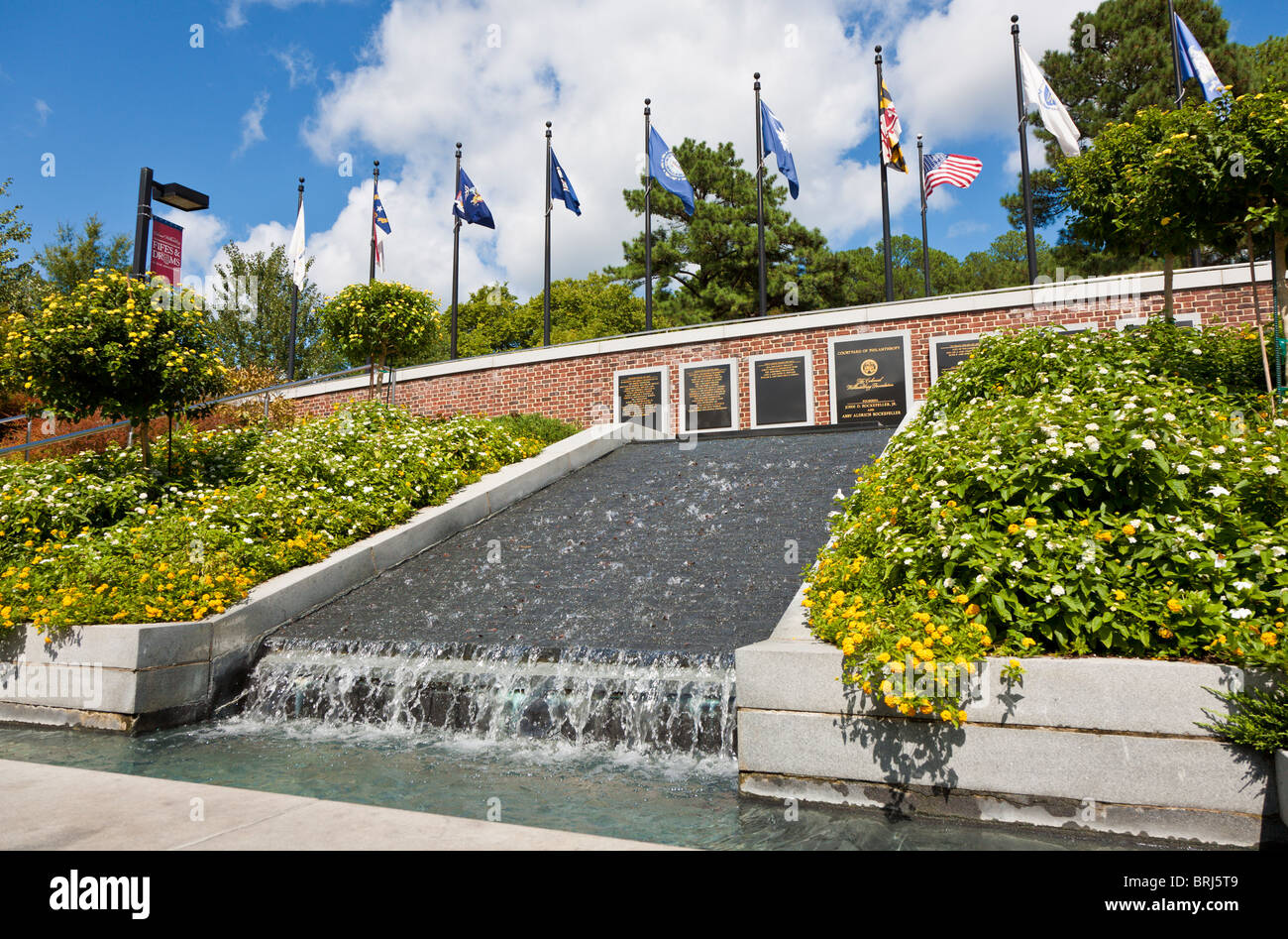 Fountain with 13 colonial flags at entrance to Colonial Williamsburg, a ...